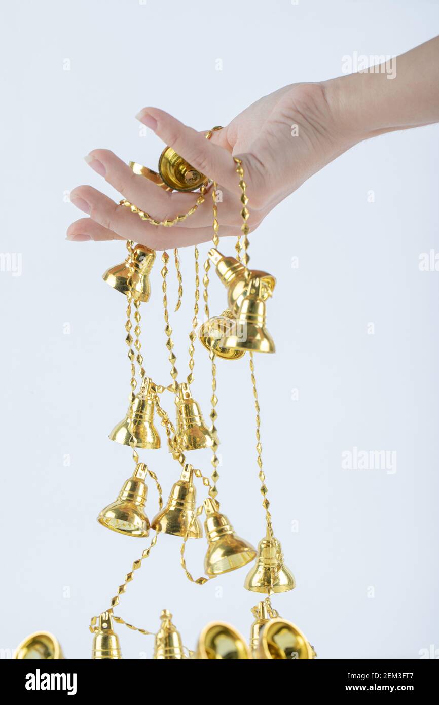 Female hand holding Christmas bells on white background Stock Photo - Alamy