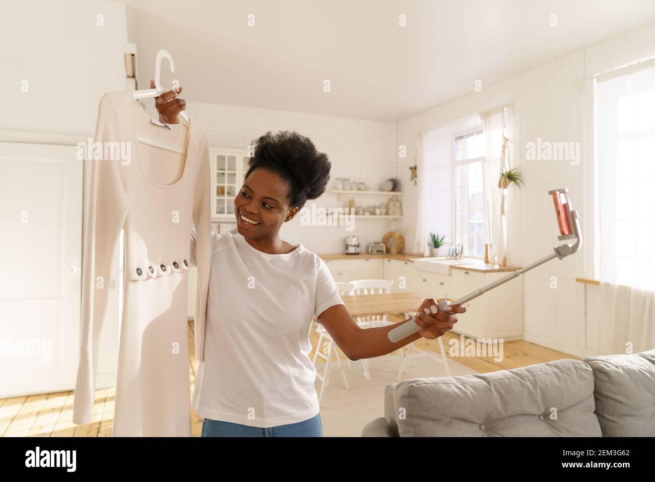 Happy African American woman showing fashion summer dress by cellphone ...