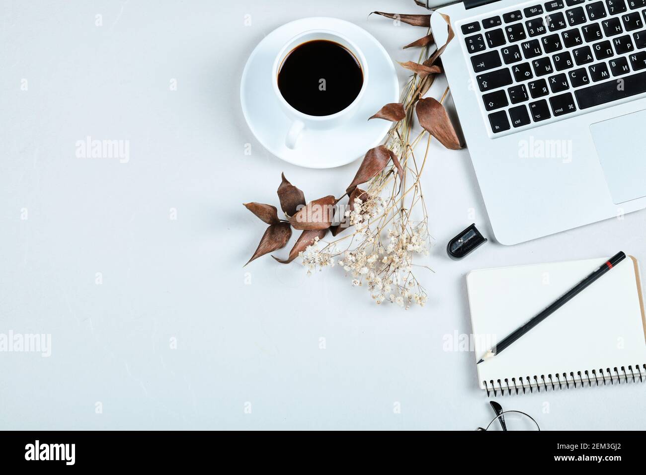 Notebook, laptop, mouse an a cup of tea on white desk Stock Photo - Alamy