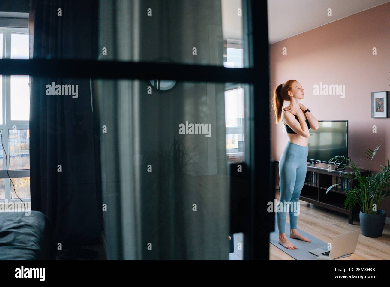 Remote side view of fit woman doing stretching exercise for arms and ...