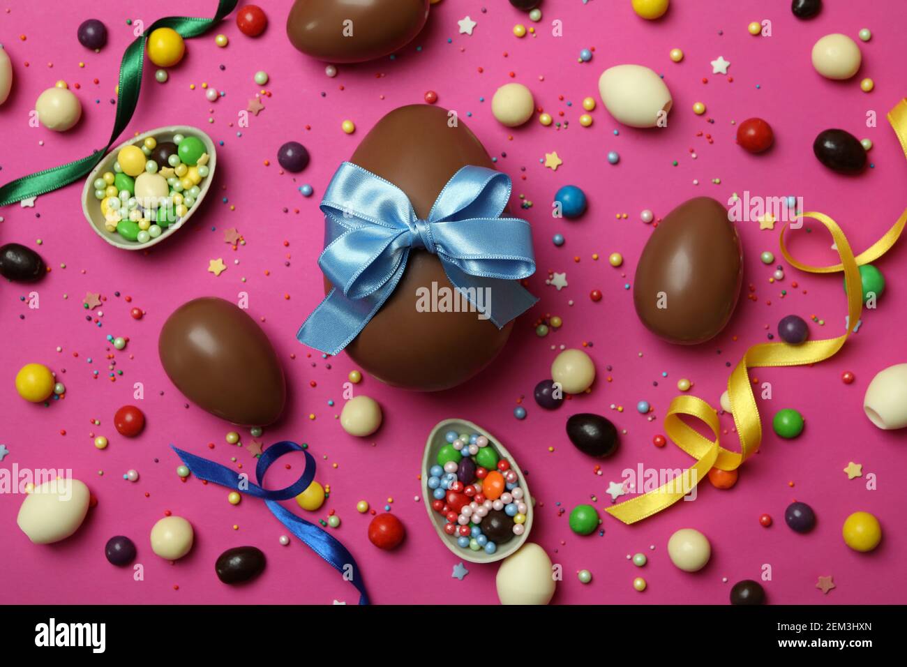 Easter chocolate eggs, candies and sprinkles on pink background Stock ...