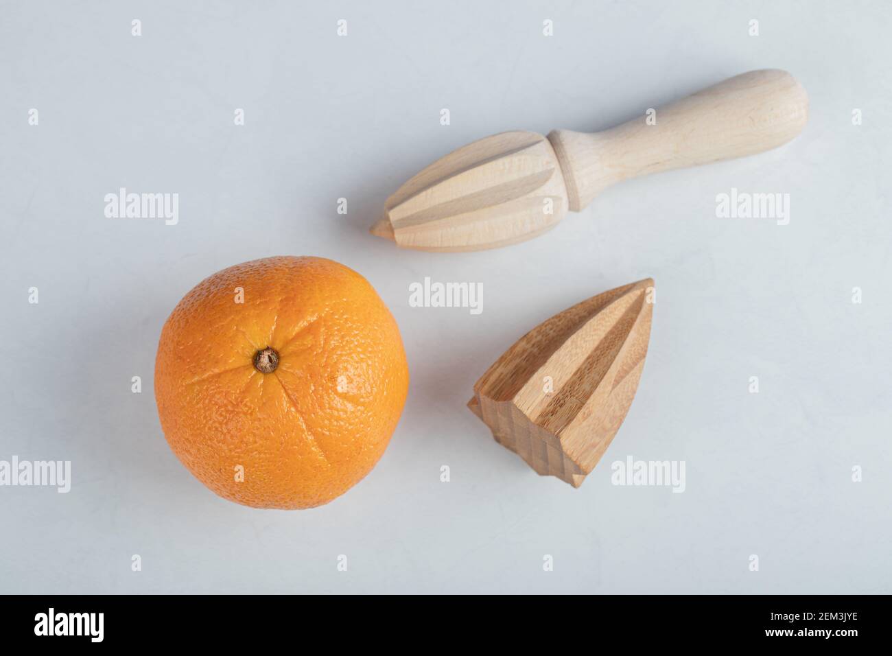 Fresh orange fruit with wooden reamers isolated on a white background ...