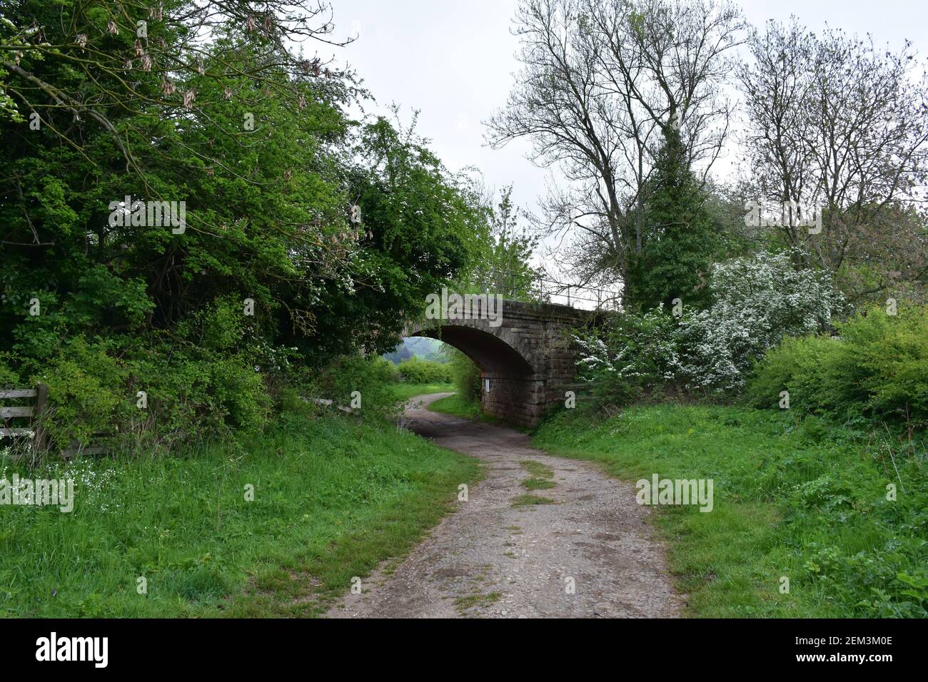 Dirt pathway passing under a curved bridge in England Stock Photo - Alamy