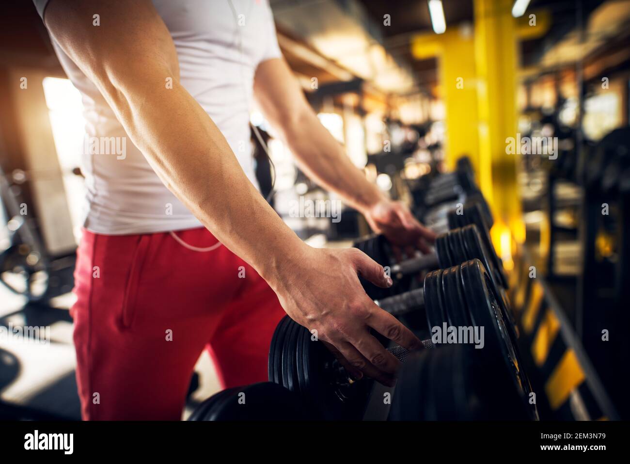 Close up focus view of hands while strong young muscular bodybuilder ...