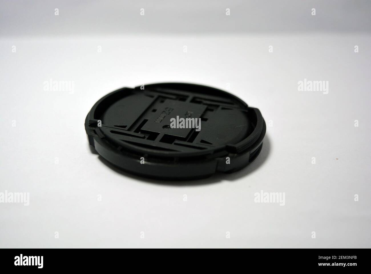 A black plastic lens cap is positioned against a white background Stock ...