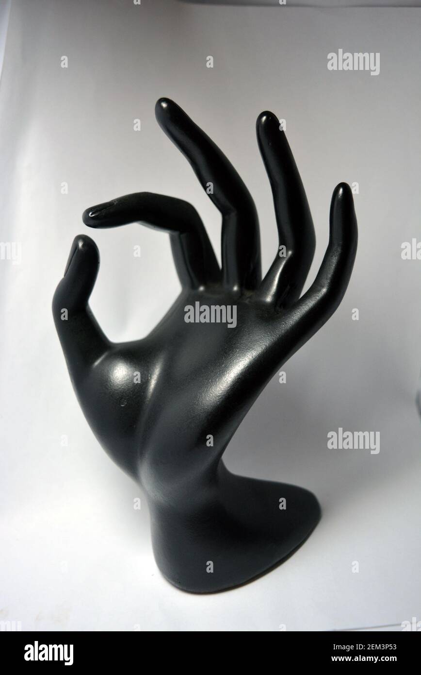 Ceramic, clay female hand covered with black matte paint is located on ...