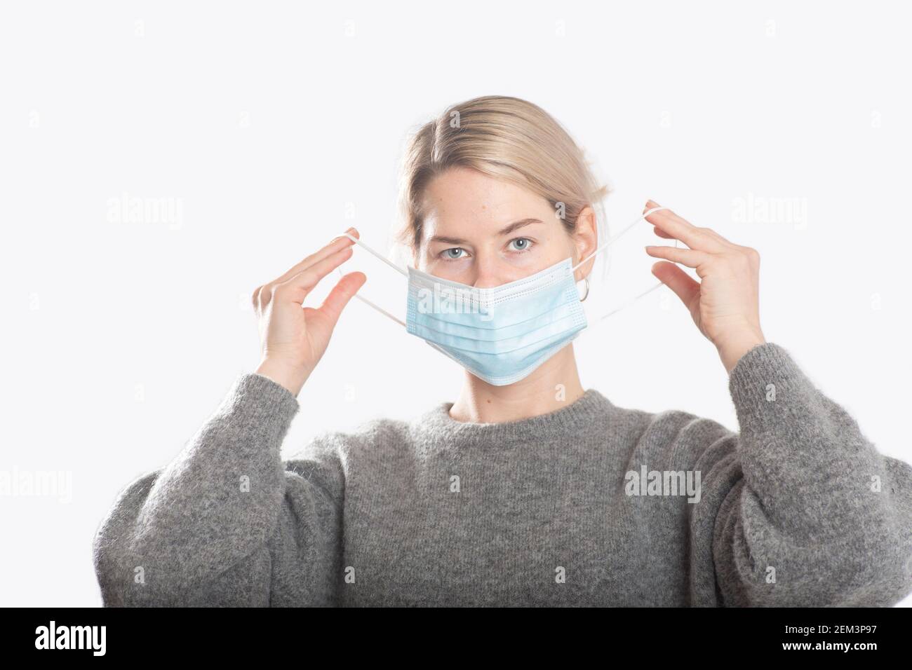 A woman removing her mask isolated on white Stock Photo - Alamy