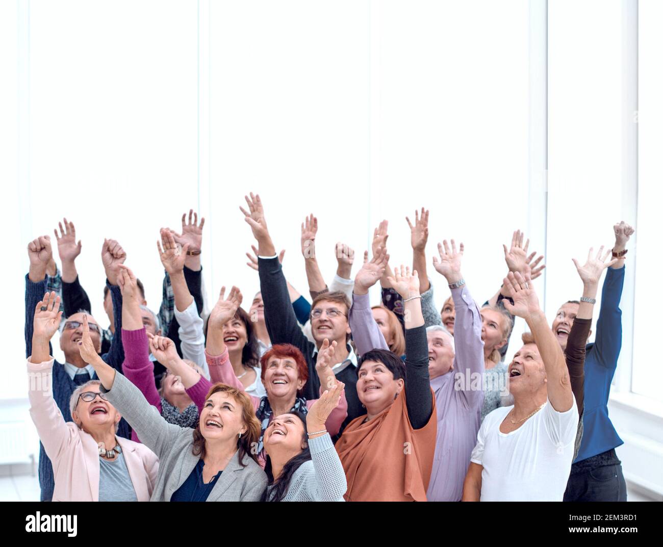 a group of older people raised their hands trying to reach Stock Photo ...