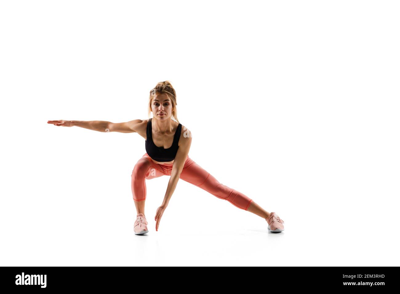 Squats. Young caucasian female model in action, motion isolated on ...