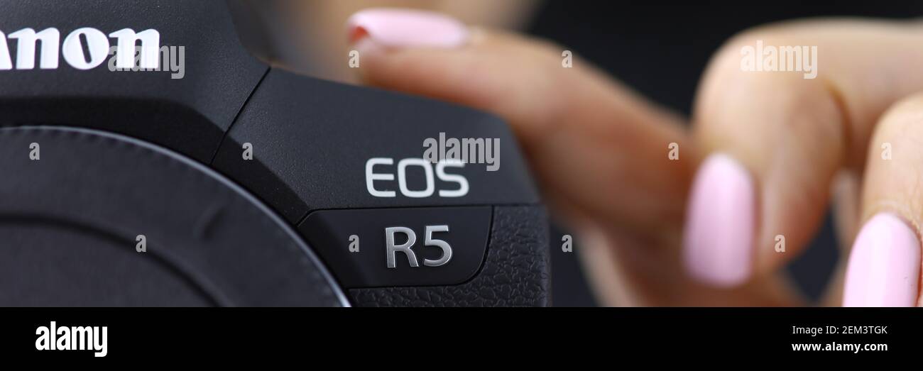Female hand holding a camera canon eos r5 closeup Stock Photo - Alamy