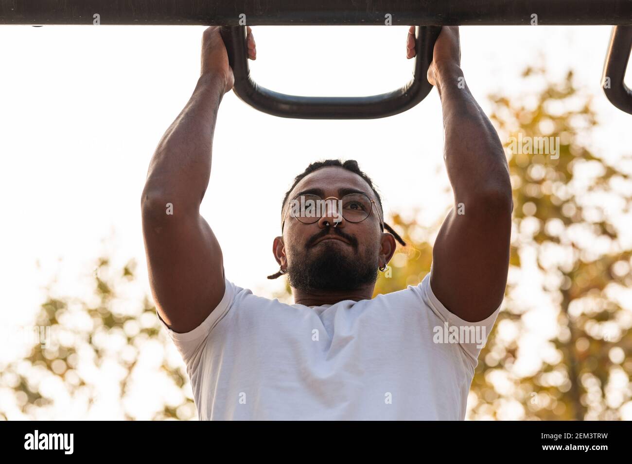african american athlete doing fitness exercises on bars, calisthenics ...