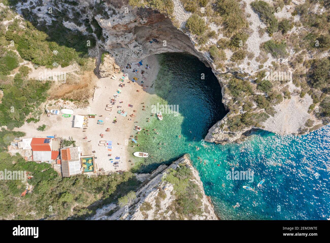 Aerial overhead drone shot of tourists swim sunbath at Stiniva beach on ...