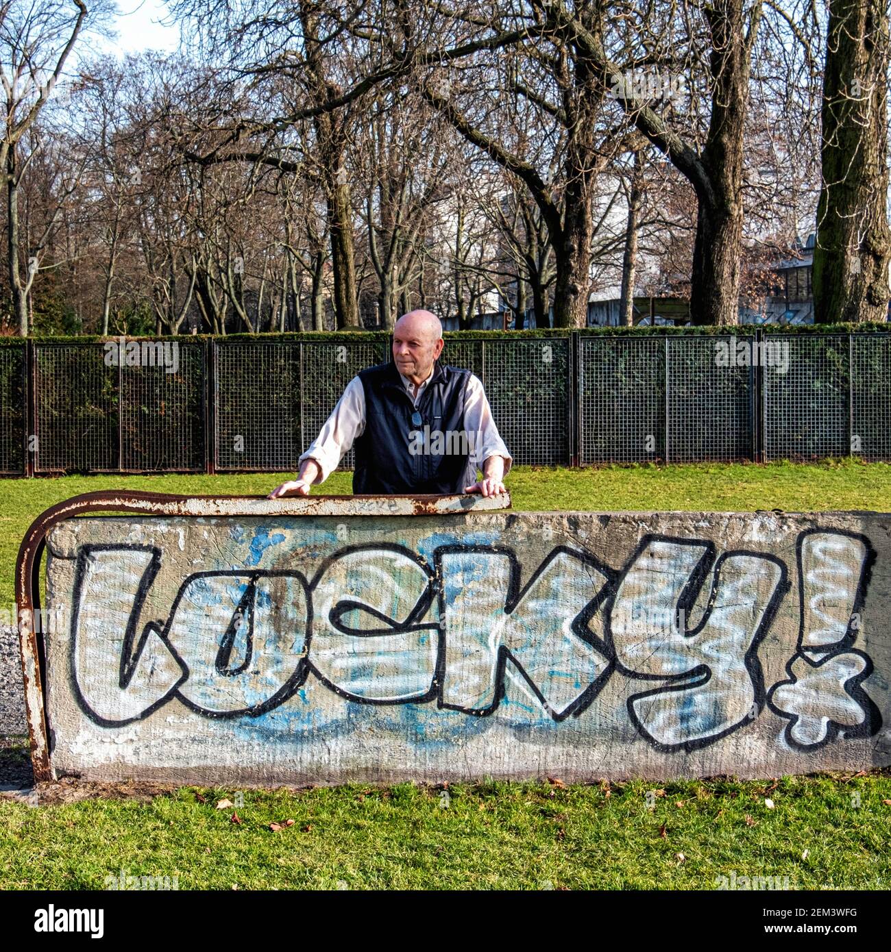 Elderly senior man standing next to Berlin Wall remnant with Lucky ...