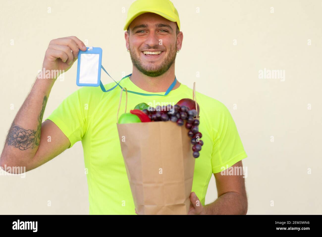 Caucasian delivery man worker in yellow color uniform handling bag of ...