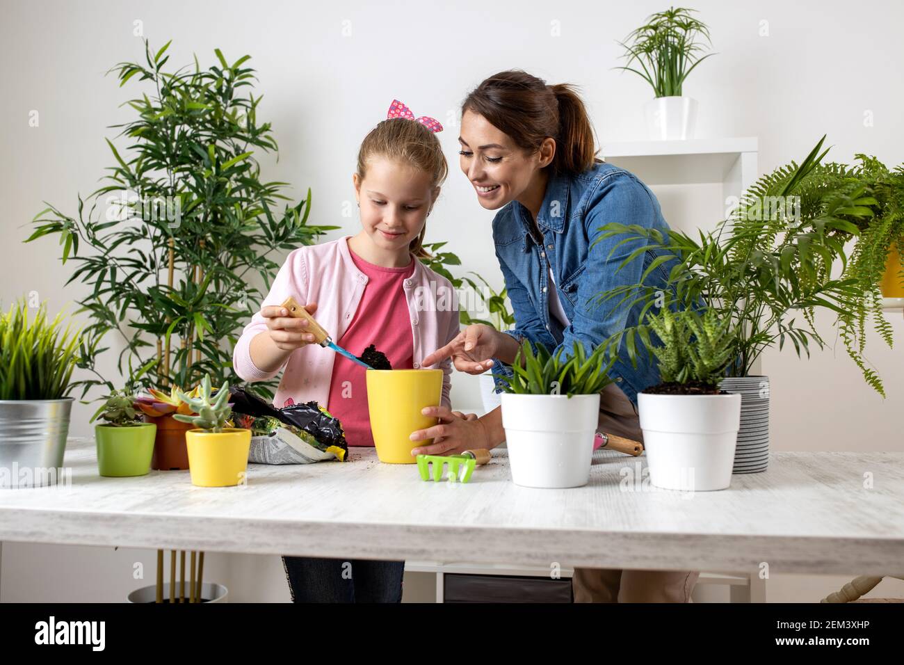 Young girl training her gardening skills with various planting tools ...