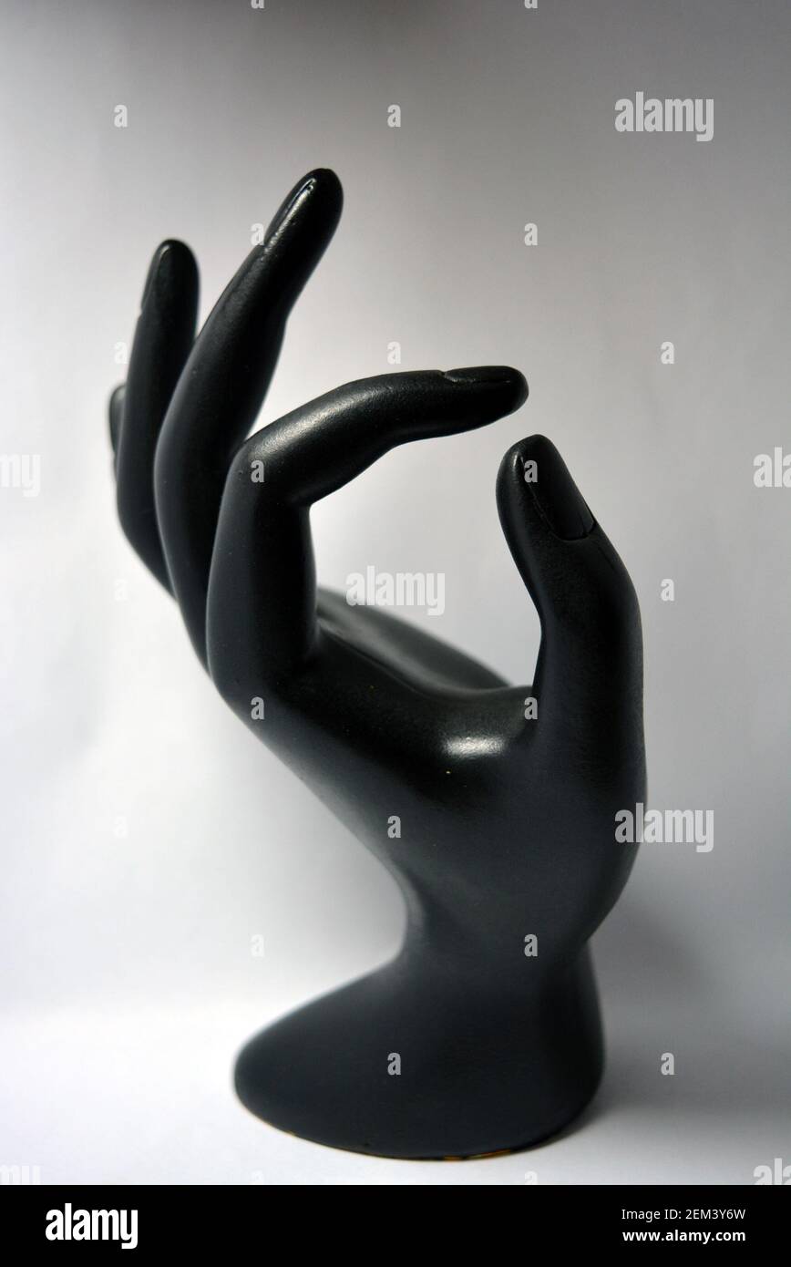 Ceramic, clay female hand covered with black matte paint is located on ...