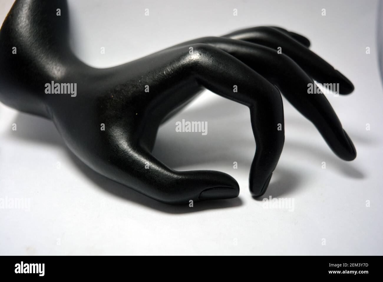Ceramic, clay female hand covered with black matte paint is located on ...