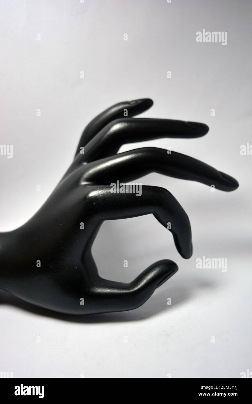 Ceramic, clay female hand covered with black matte paint is located on ...