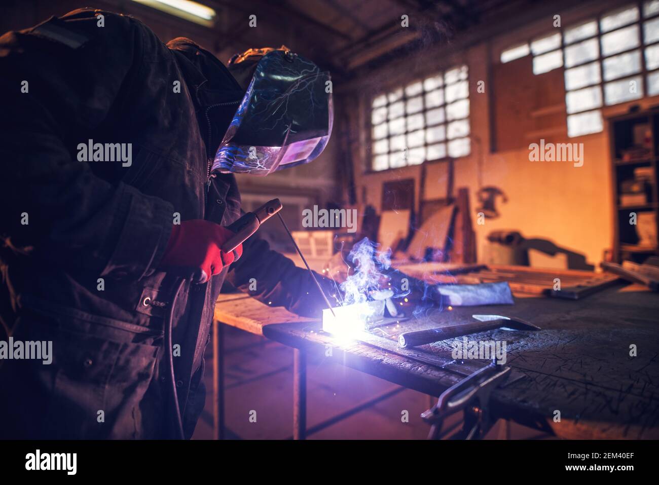 Close up side view of focused professional welder with protection mask ...
