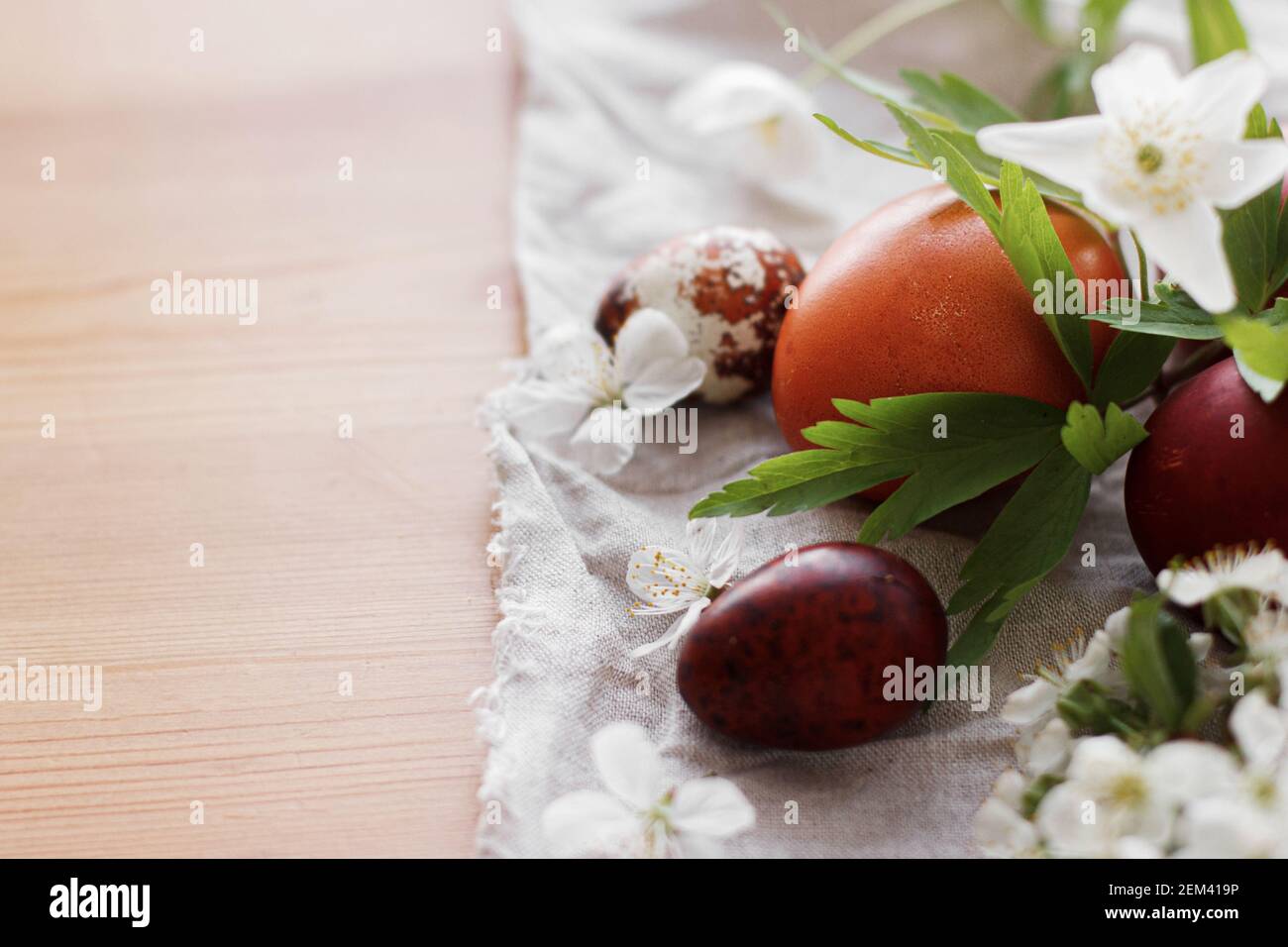 Modern easter eggs with spring flowers on rustic linen cloth on wooden ...