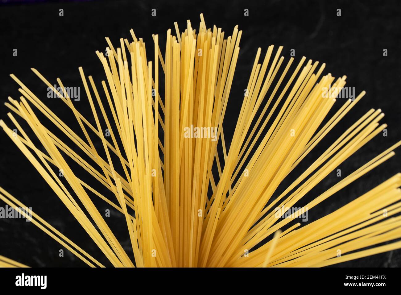 Raw dry spaghetti on a black background Stock Photo - Alamy