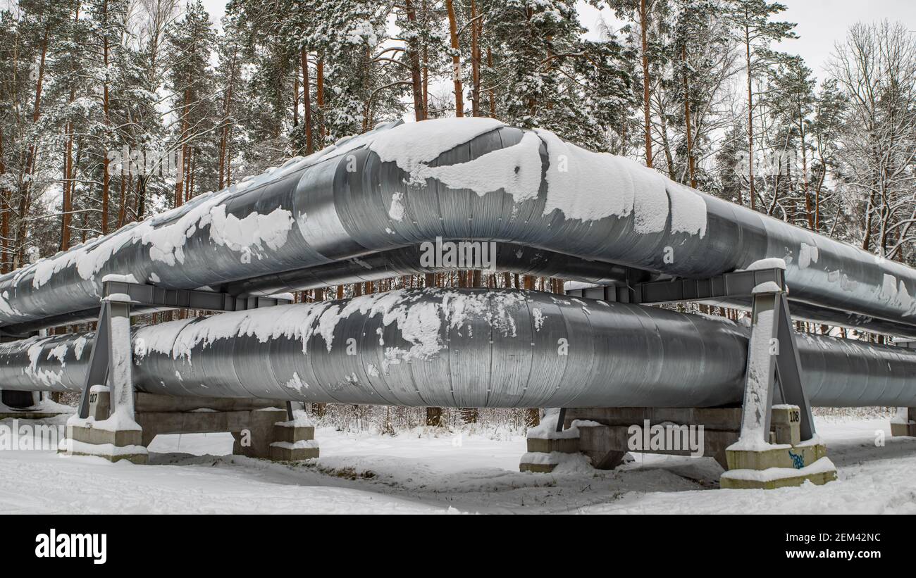 Huge industrial pipelines of central heating system. Snow on pipes ...