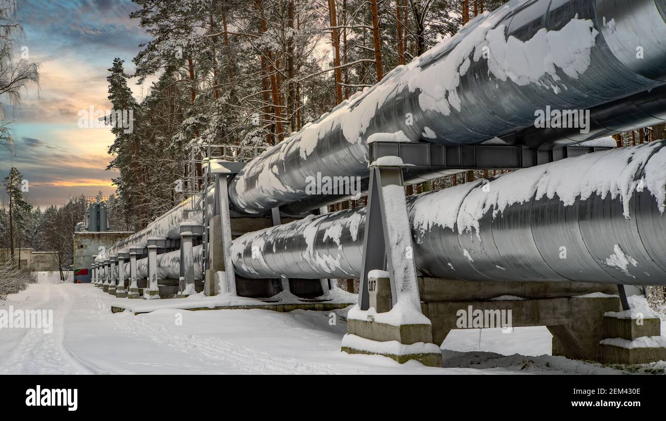 Huge industrial pipelines of central heating system. Snow on pipes ...