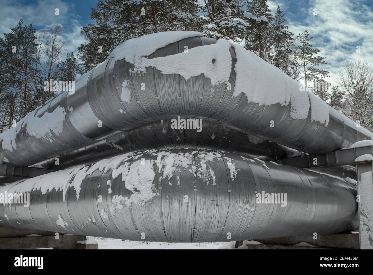 Huge industrial pipelines of central heating system. Snow on pipes ...