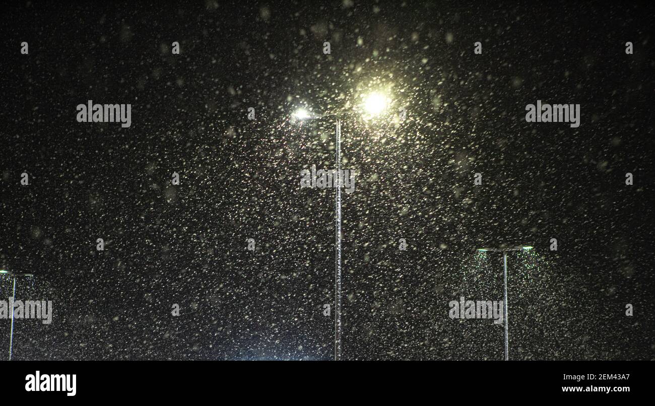 Snow falling at night on the background of a burning street lamp Stock ...