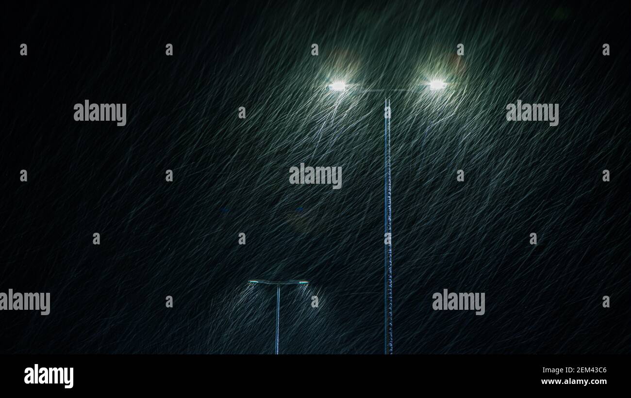Snow falling at night on the background of a burning street lamp Stock ...