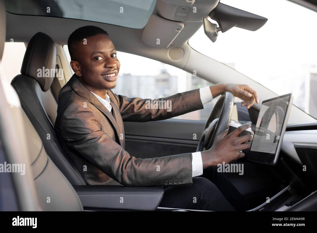 Happy smiling African American male driver sitting behind the self ...