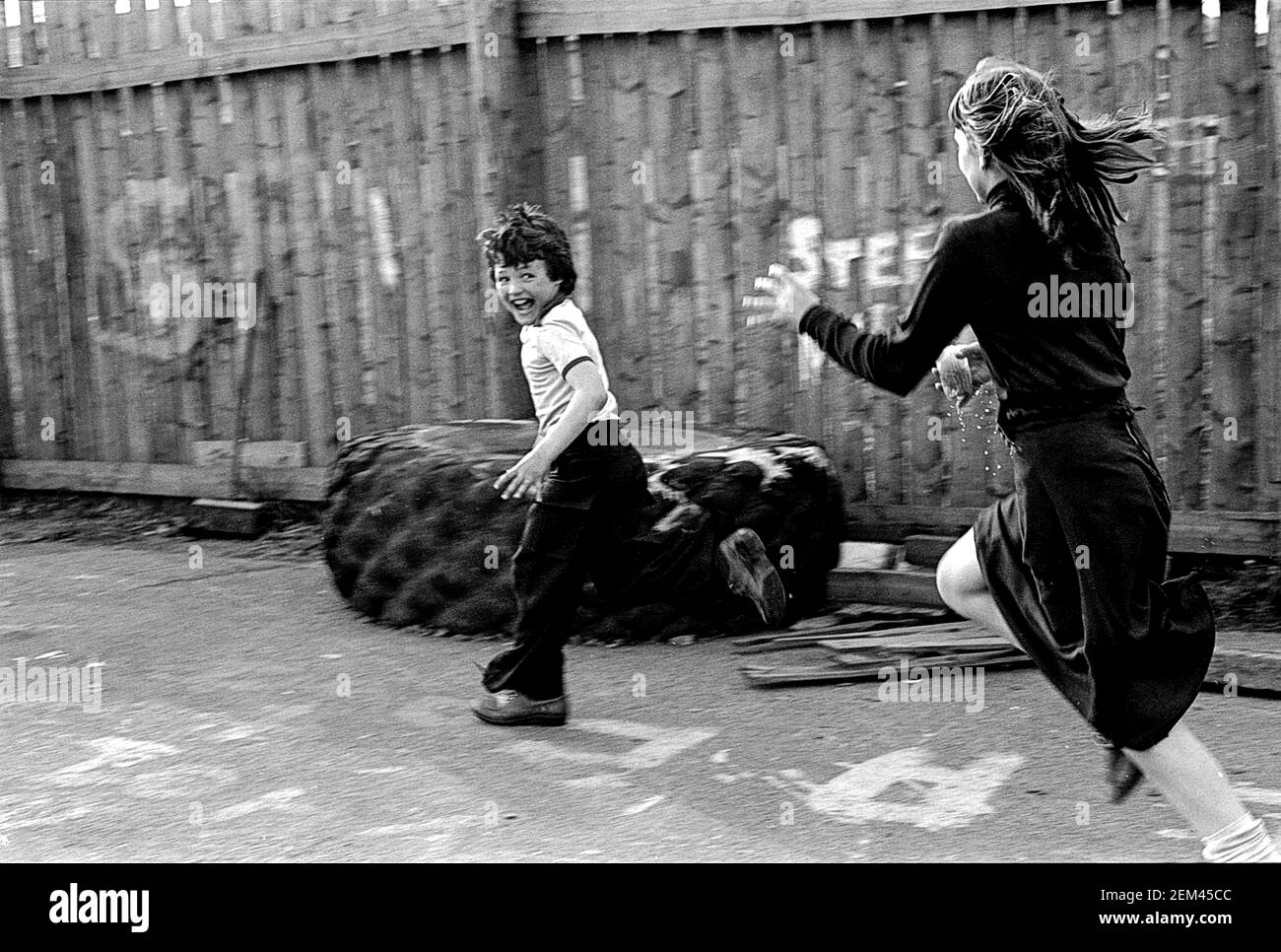 Childrens Adventure Playground girl chasing boy with water Stock Photo ...