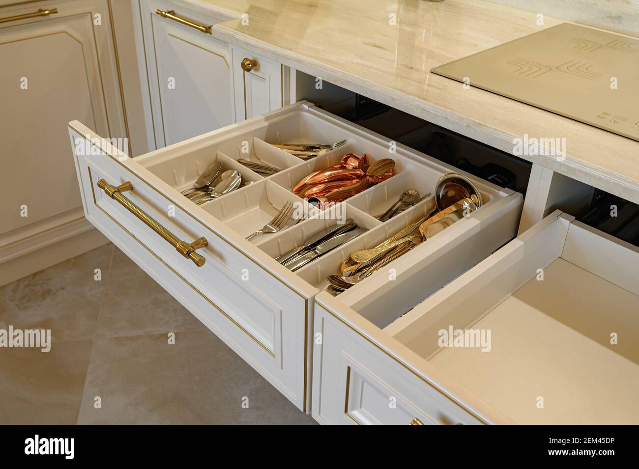 Drawer pulled out in cabinet at luxury beige and gold classic kitchen ...