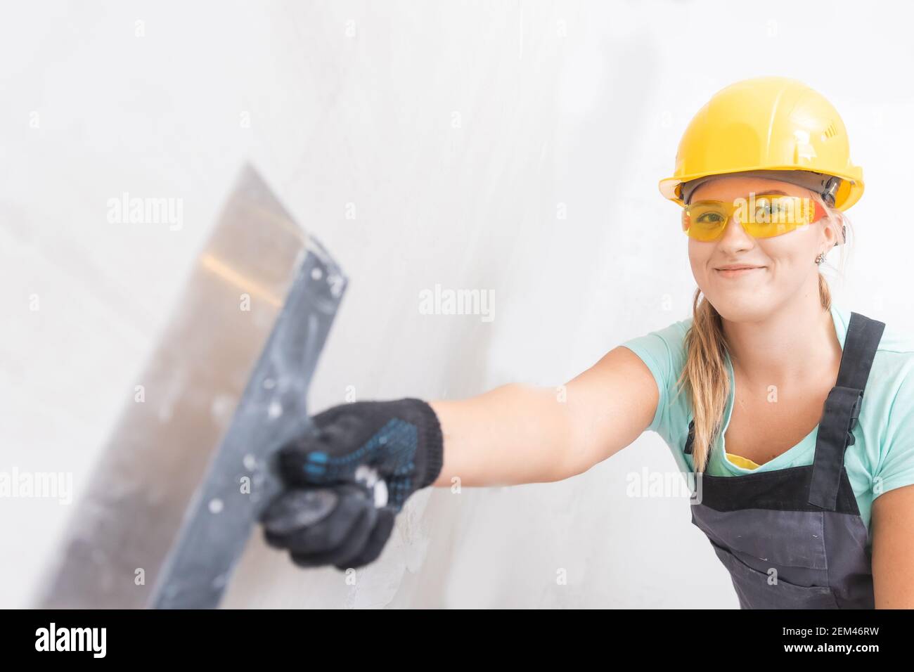 Female molar plasterer worker prepares the wall for applying plaster ...