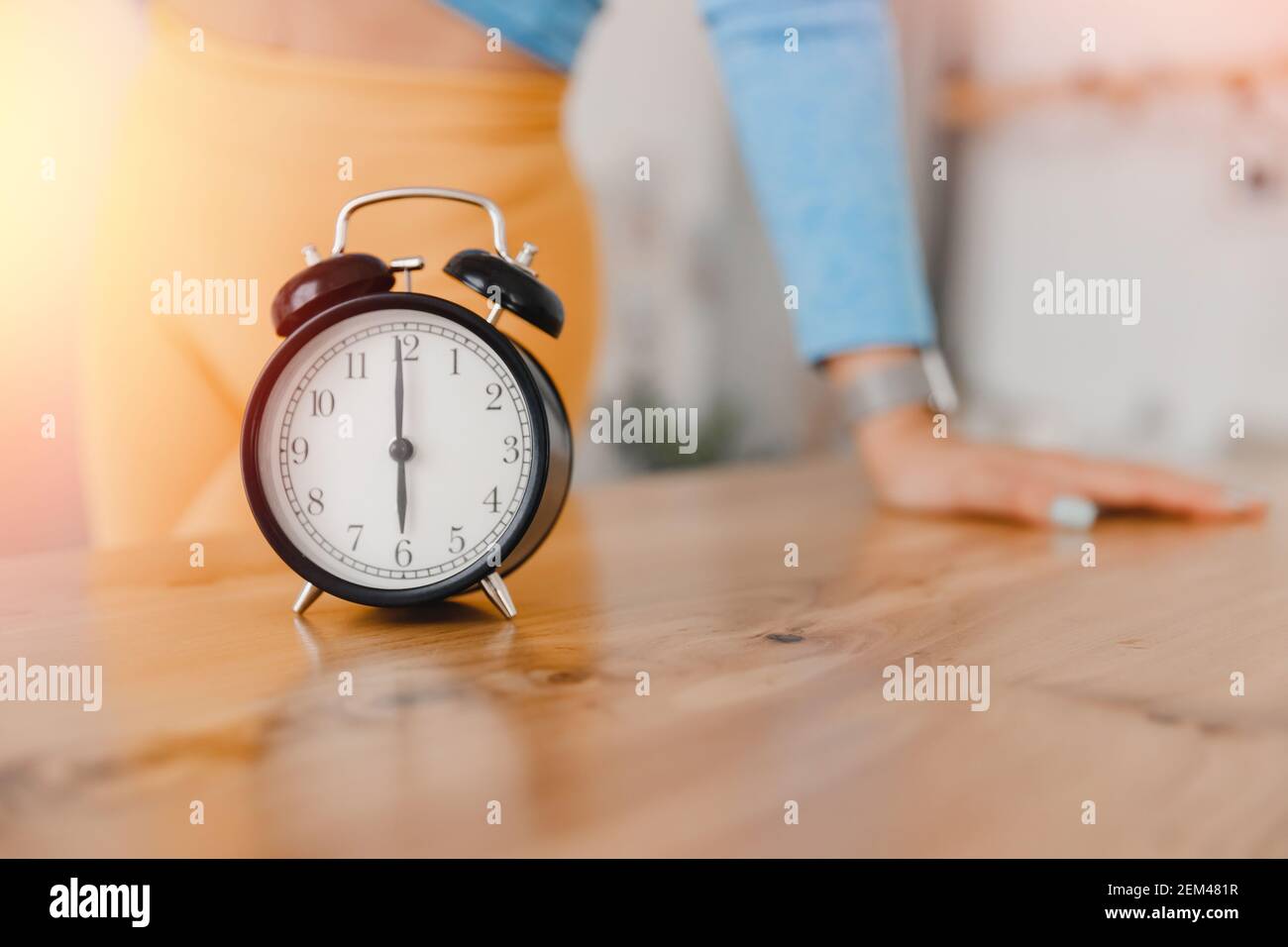 Healthy sleep concept. Girl in sportswear alarm clock six in morning ...
