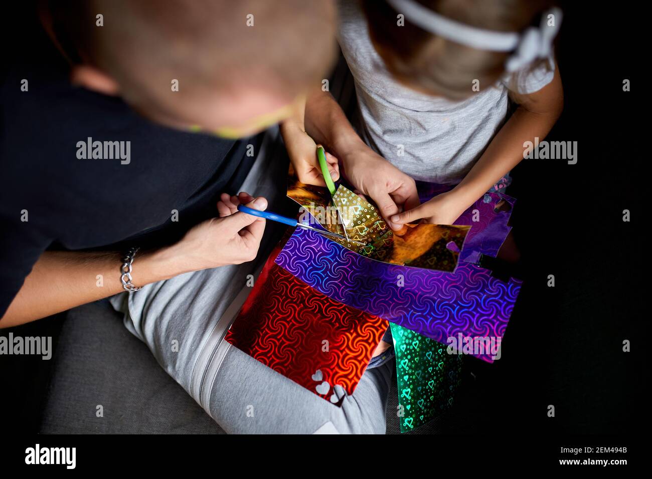 Daughter and father having fun making craft together at home on the ...