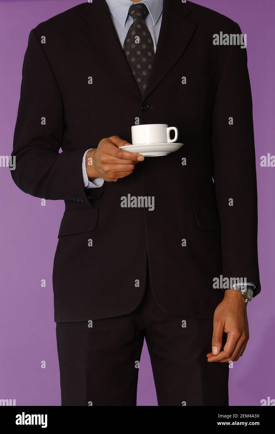 Faceless white business man in a black suit with a blue tie holding a ...