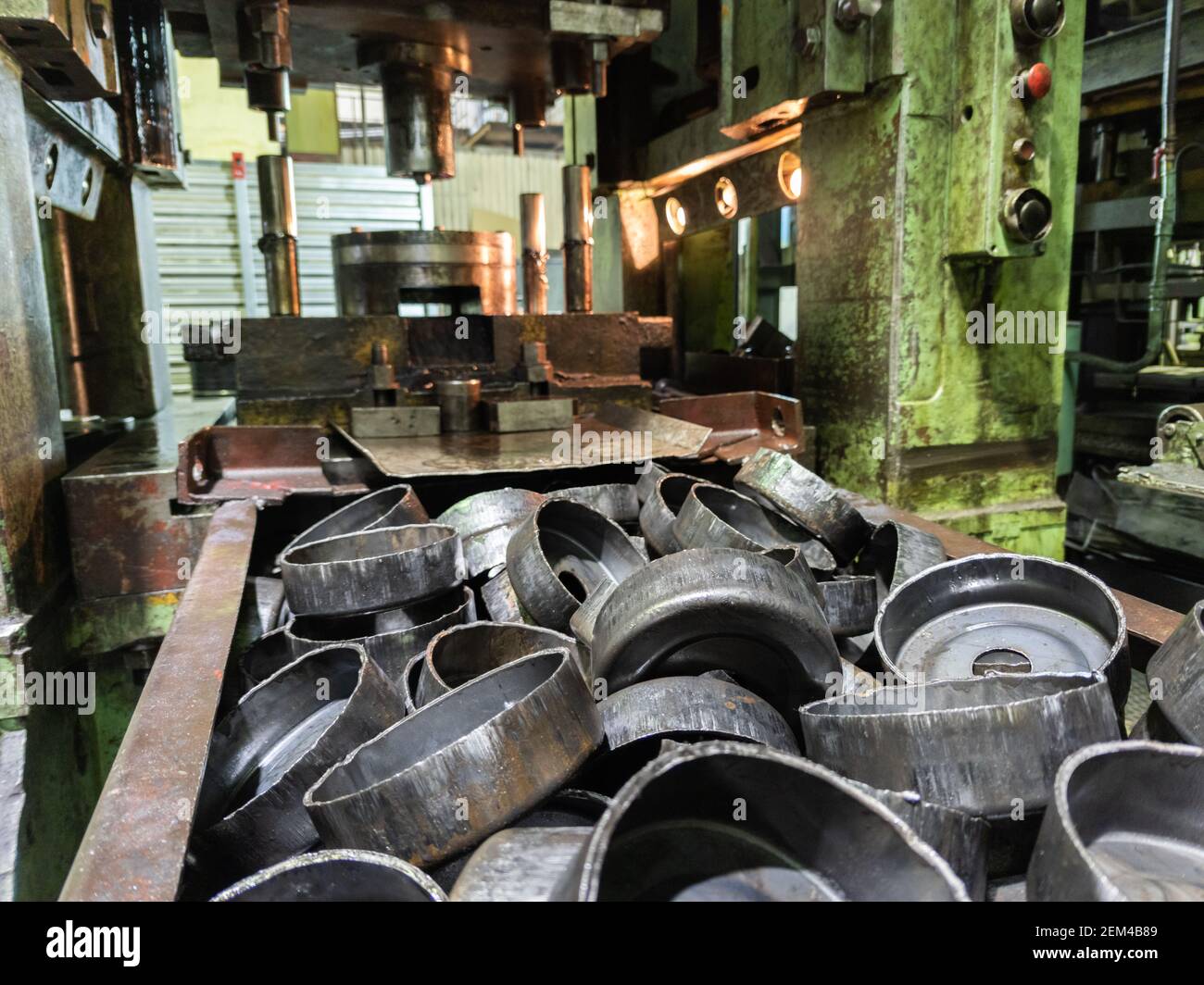 pile of stamped thick sheet black metal round parts after a hood ...