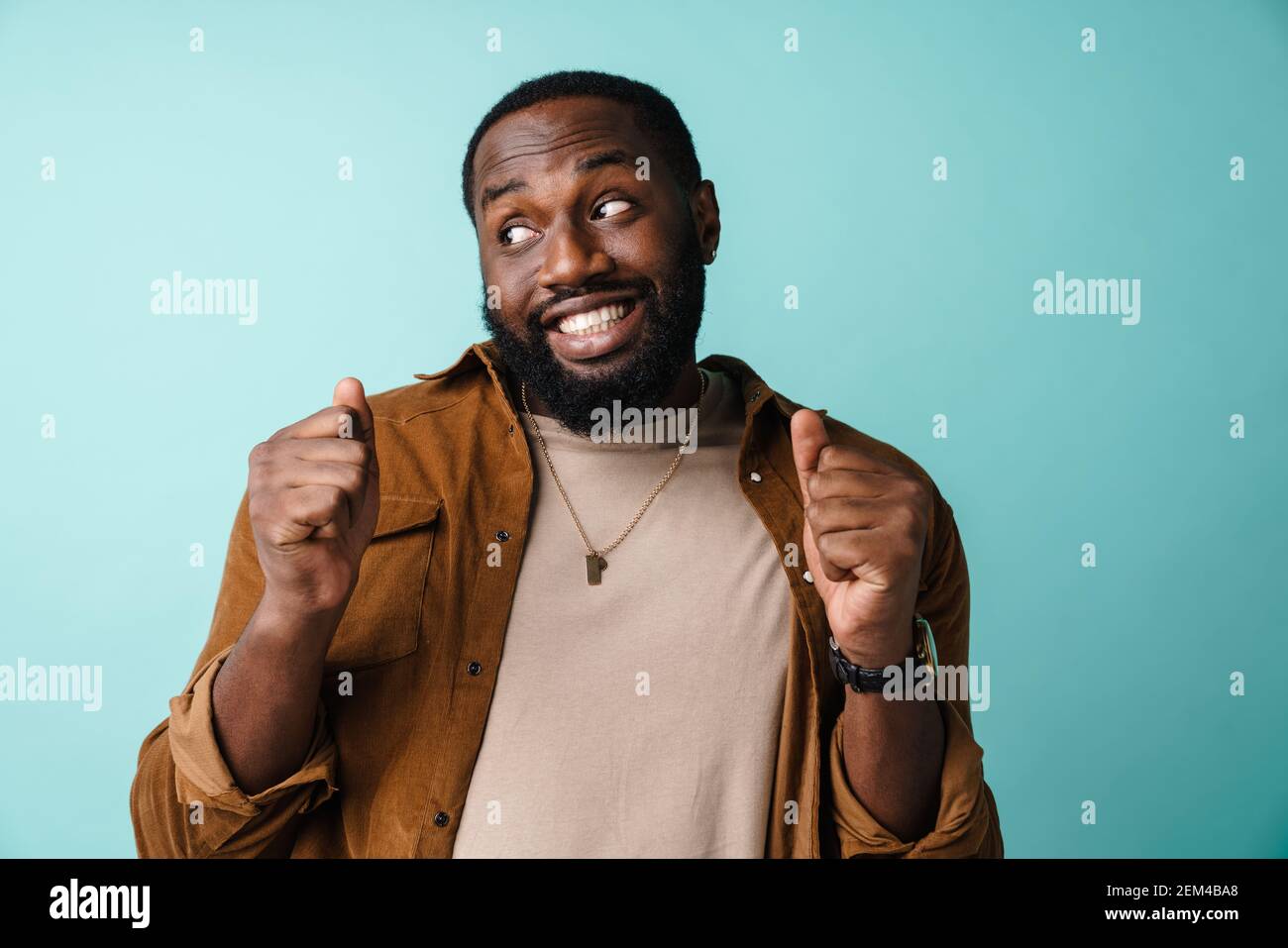 Close up of a happy excited african man isolated over blue background ...
