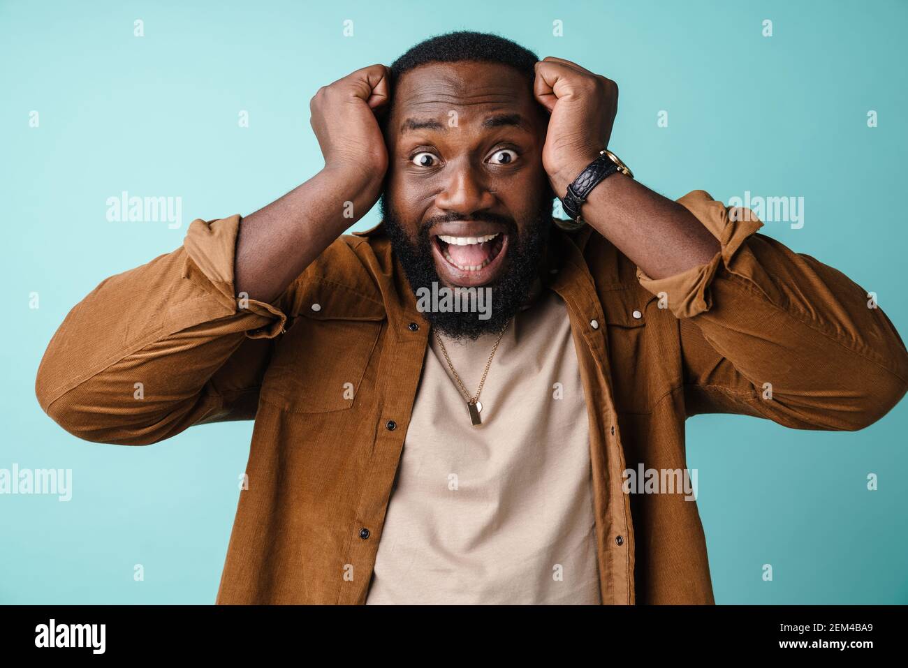 Close up of a happy excited african man isolated over blue background ...