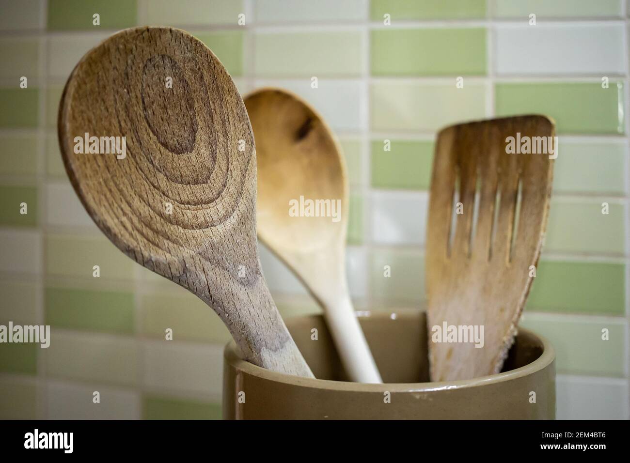 Kitchen utensils in a ceramic pot - wooden spoons and spatula used for ...