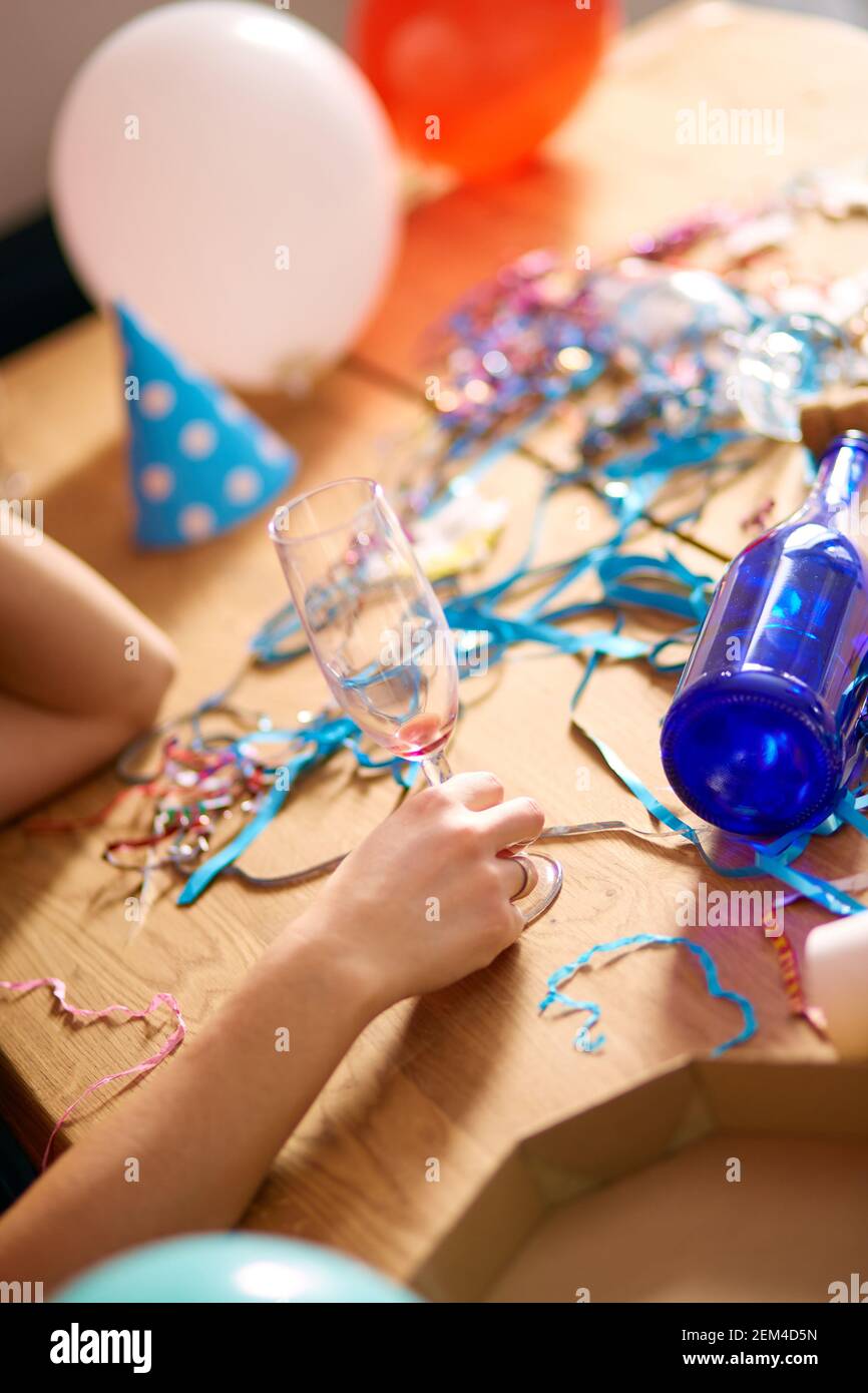 Close up of hand woman hold a glass of champagne, sleeping at table in ...