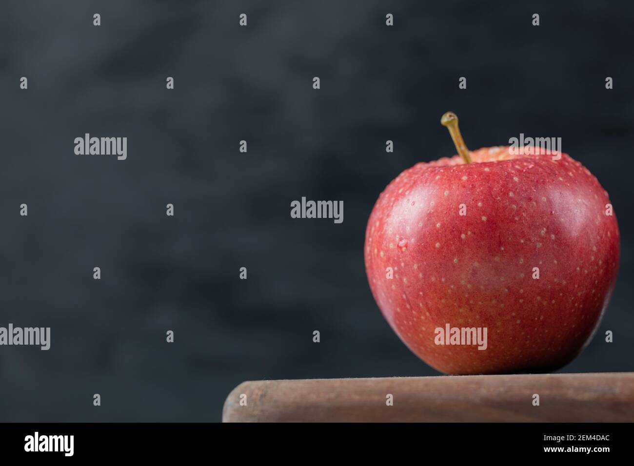A single red apple on a wooden board Stock Photo - Alamy