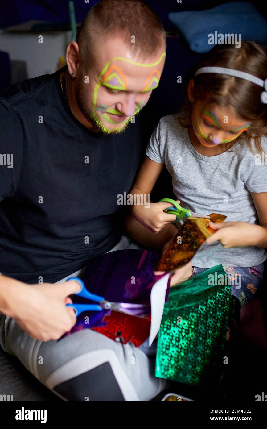Daughter and father having fun making craft together at home on the ...