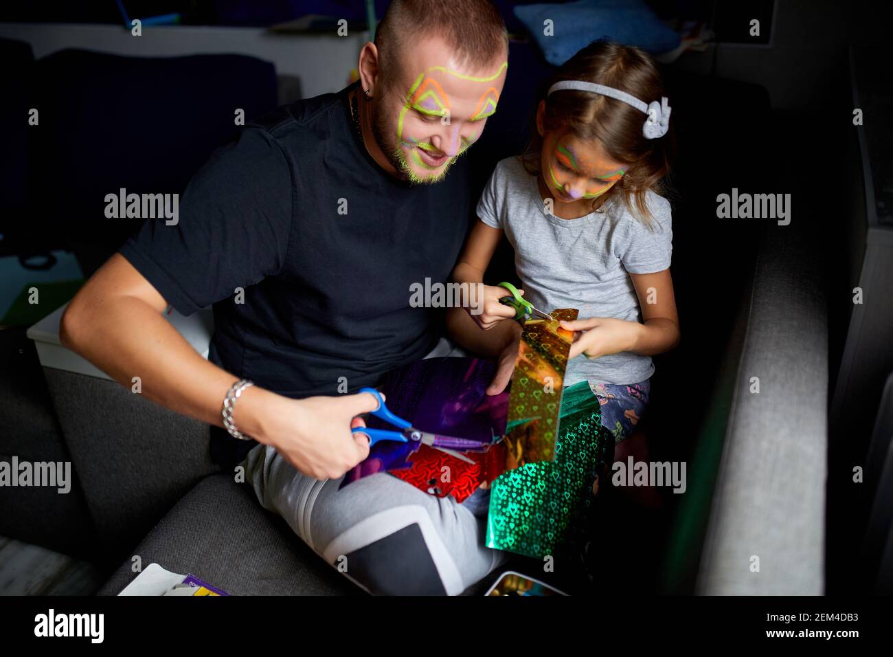 Daughter and father having fun making craft together at home on the ...