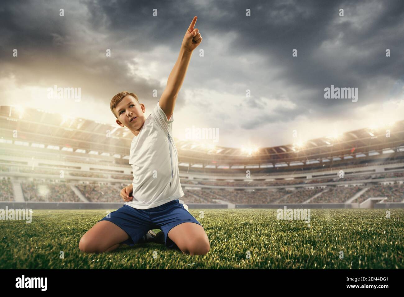 Junior football or soccer player at stadium in flashlight. Young male ...