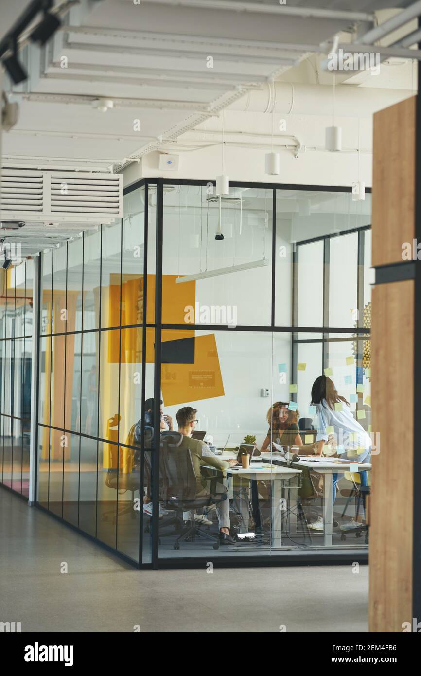 Professional workers discussing issues inside a glass office Stock ...