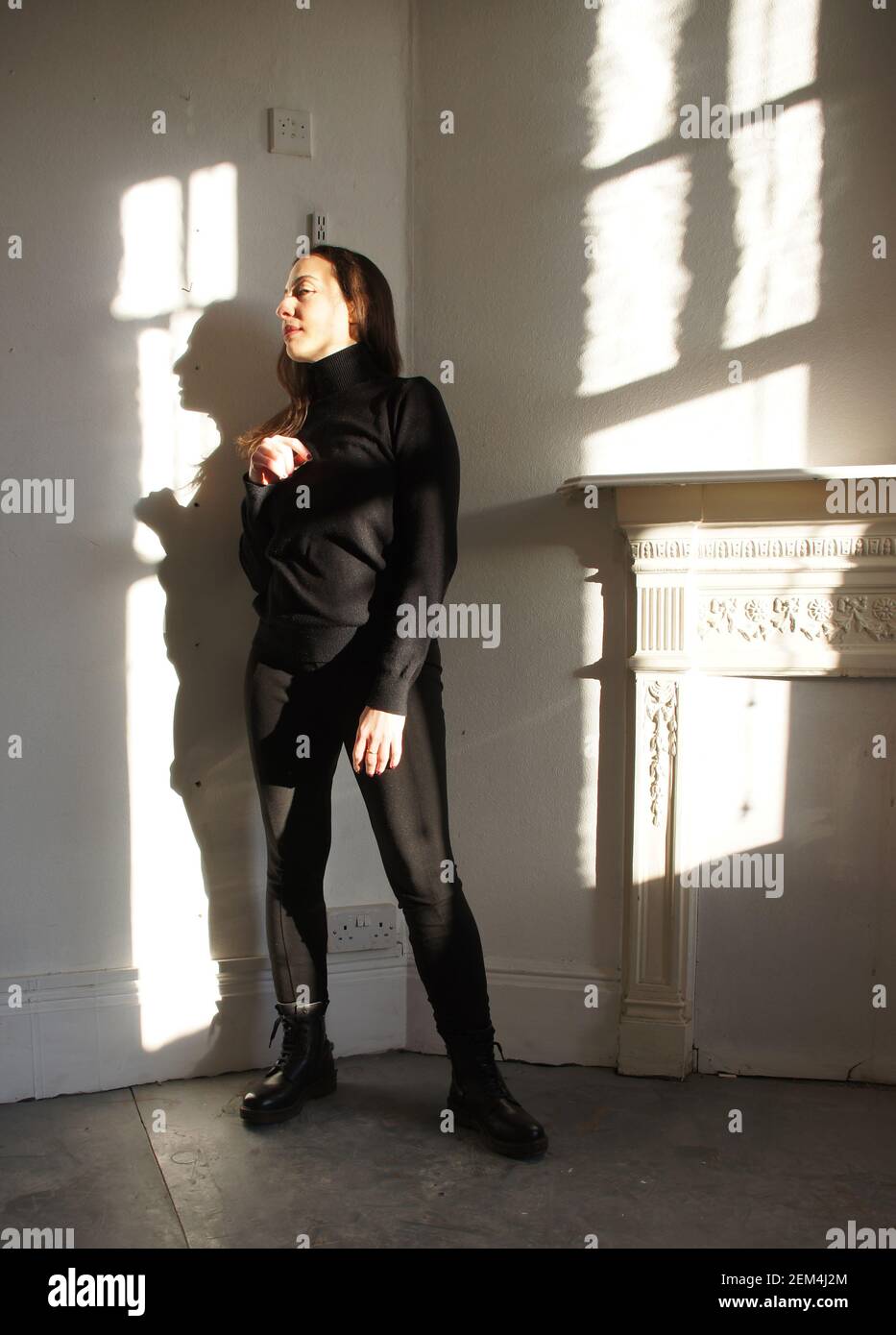 Woman standing indoors with shadows and sunlight effects Stock Photo ...