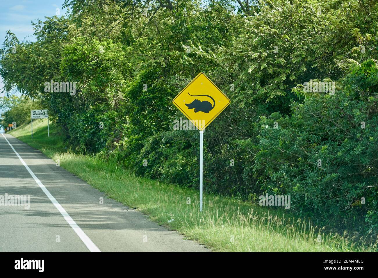 black and yellow road sign standing next to the street in Colombia at ...