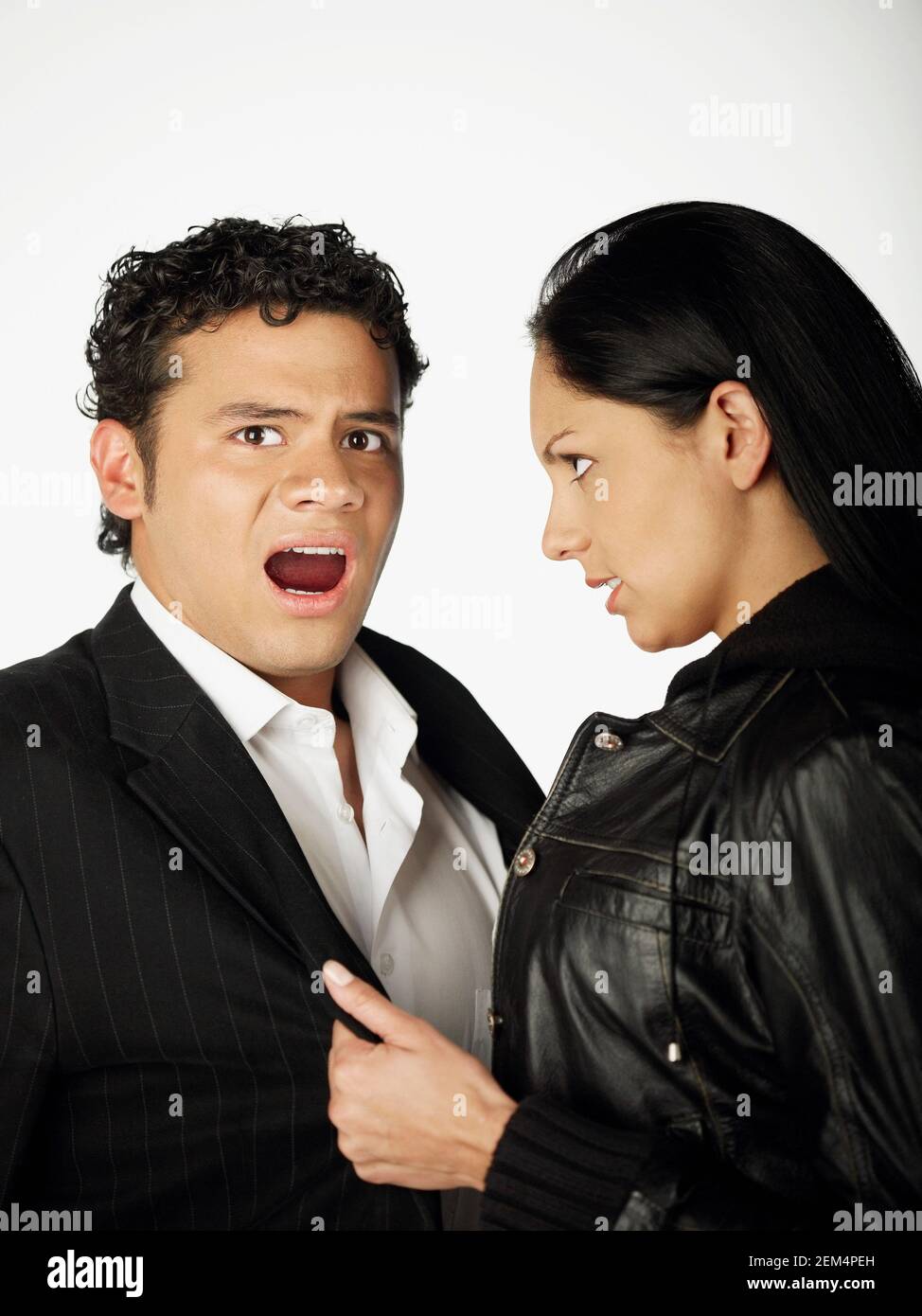 Close-up of a young woman pulling a young man by his jacket Stock Photo ...